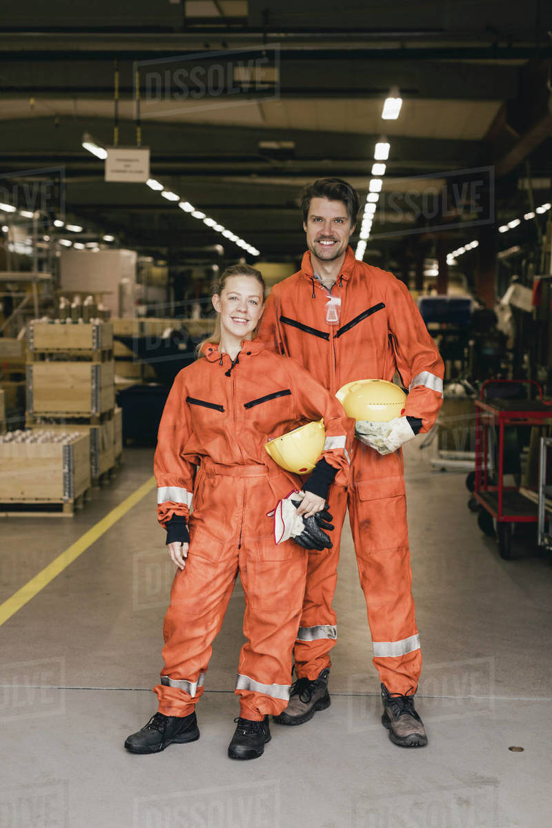Portrait of smiling male and female coworkers in uniform standing at ...