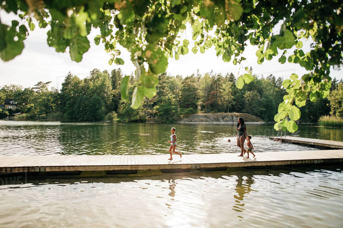 Family enjoying at lake during vacation - Stock Photo - Dissolve