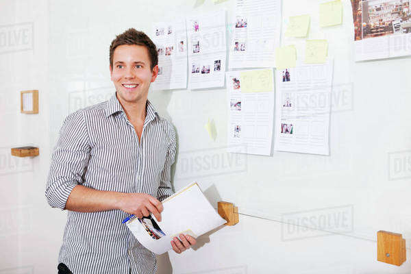 Happy man holding papers - Stock Photo - Dissolve