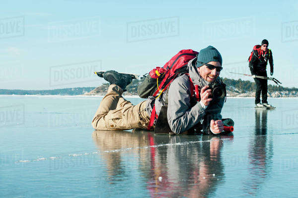 Man laying on ice - Stock Photo - Dissolve
