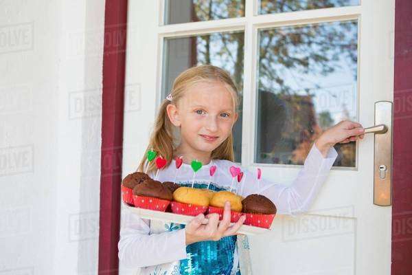 Portrait of girl carrying cakes on patio - Royalty-free Stock Photo ...