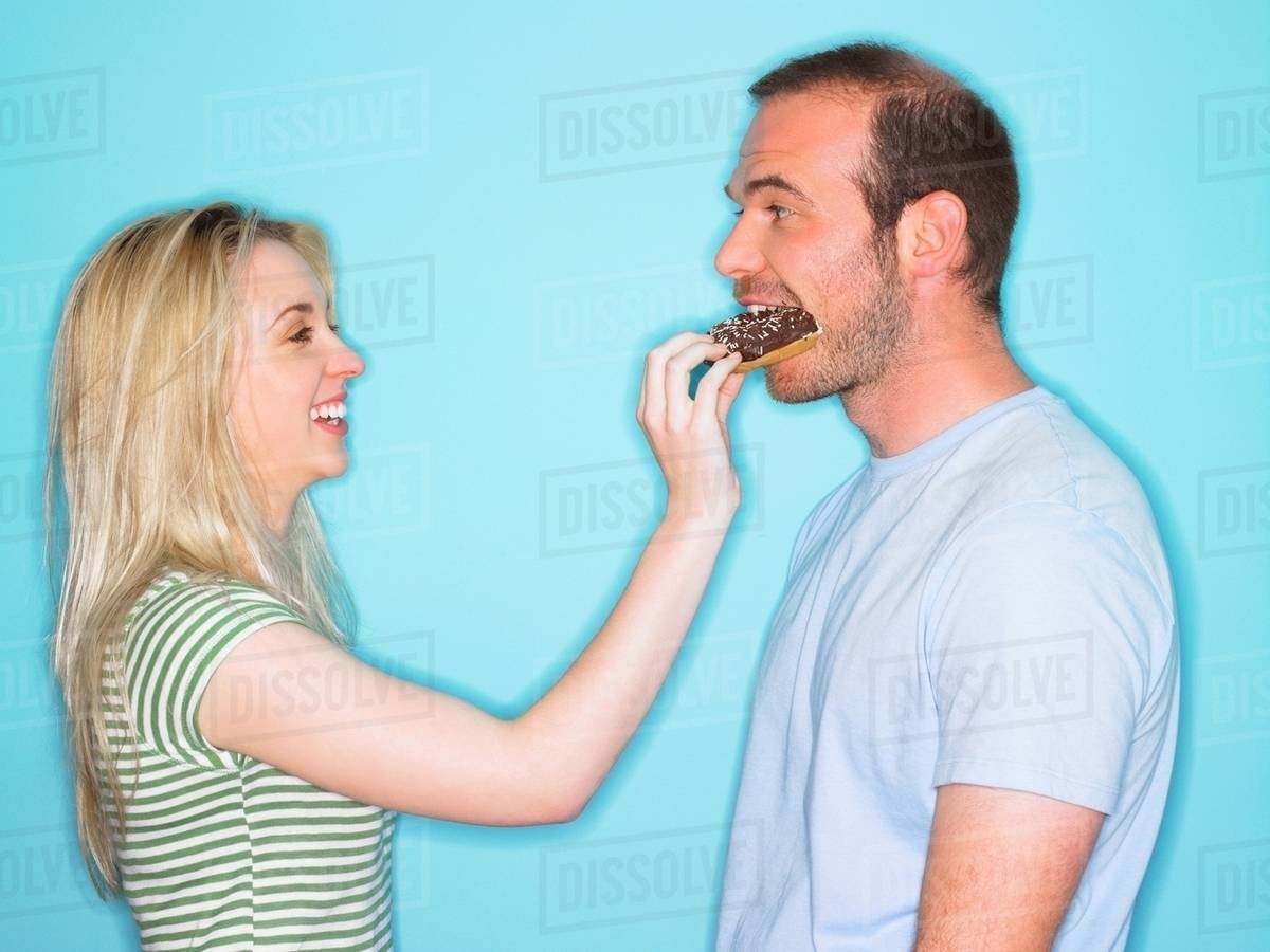 Young woman feeding man with cake - Royalty-free Stock Photo | Dissolve