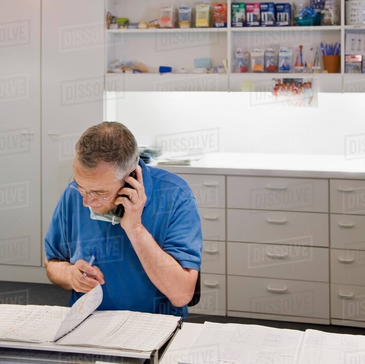 Male dentist talking on a phone - Royalty-free Stock Photo | Dissolve