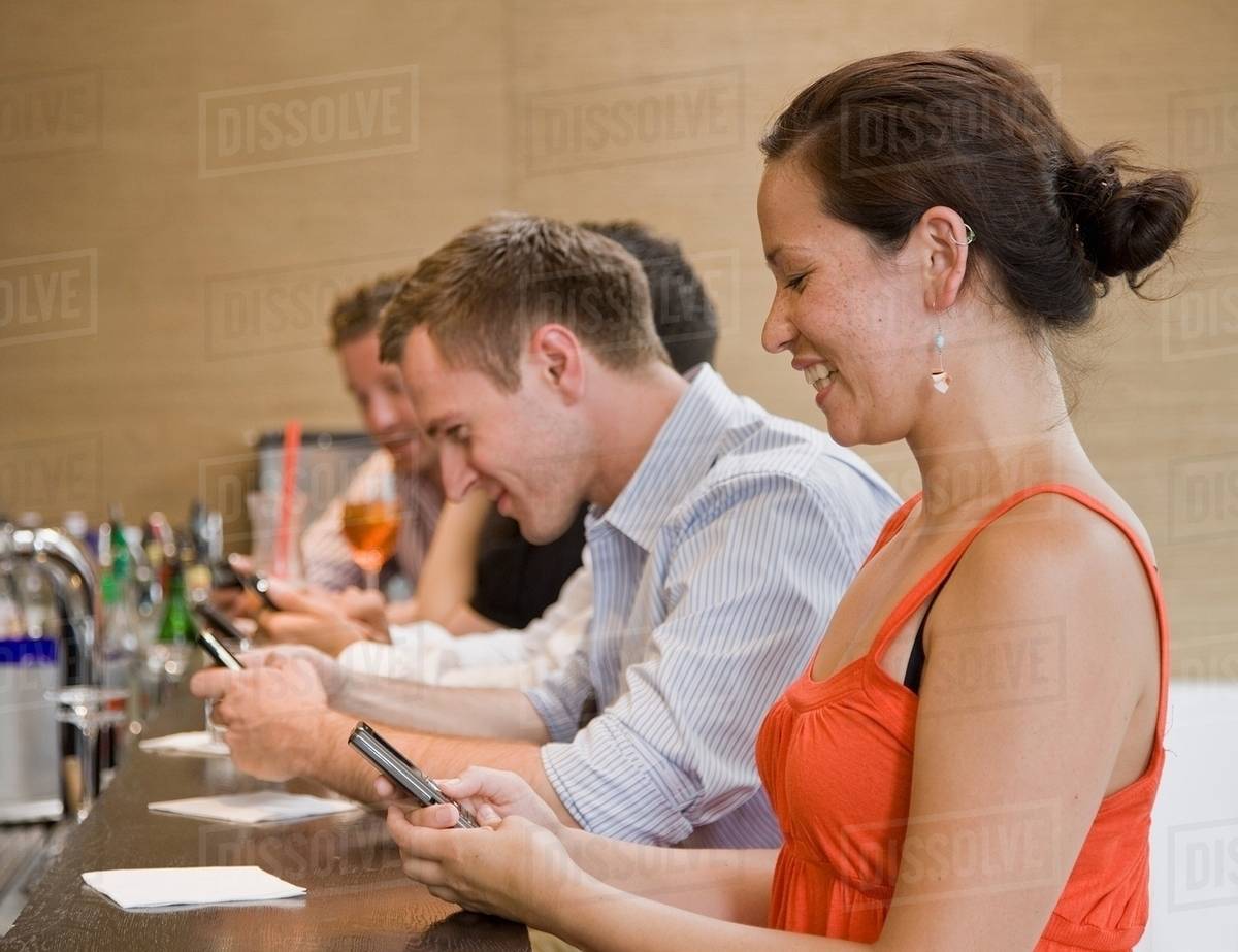 Girl text messaging at bar - Royalty-free Stock Photo | Dissolve