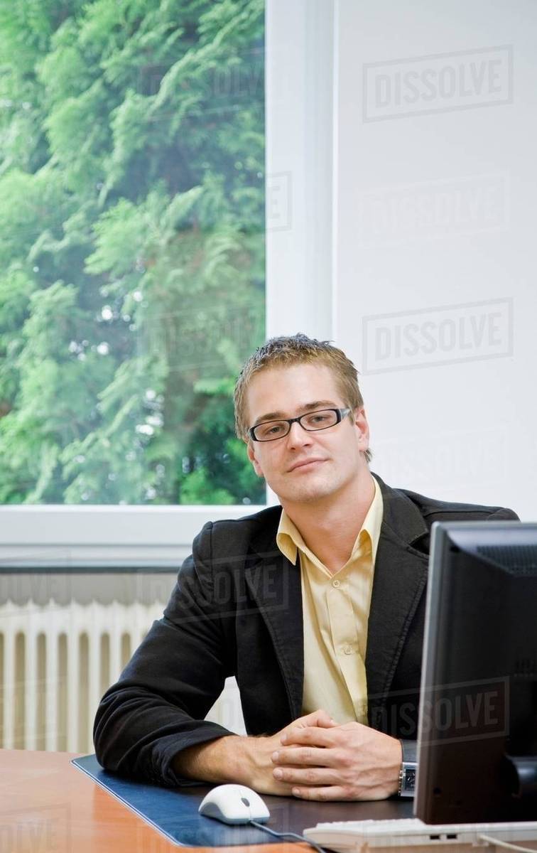 Portrait of man on computer in office - Royalty-free Stock Photo | Dissolve