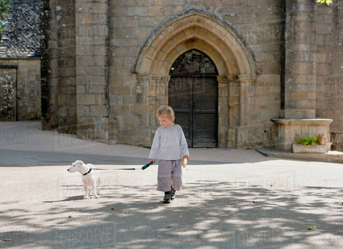 Young boy walking dog - Royalty-free Stock Photo | Dissolve