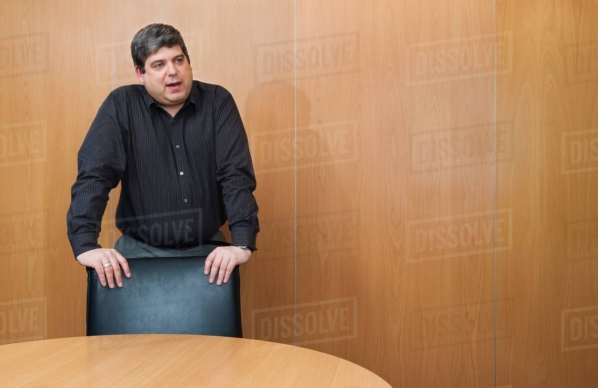 Man standing talking in boardroom - Royalty-free Stock Photo | Dissolve