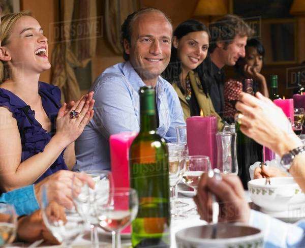 People laughing at dinner table - Stock Photo - Dissolve