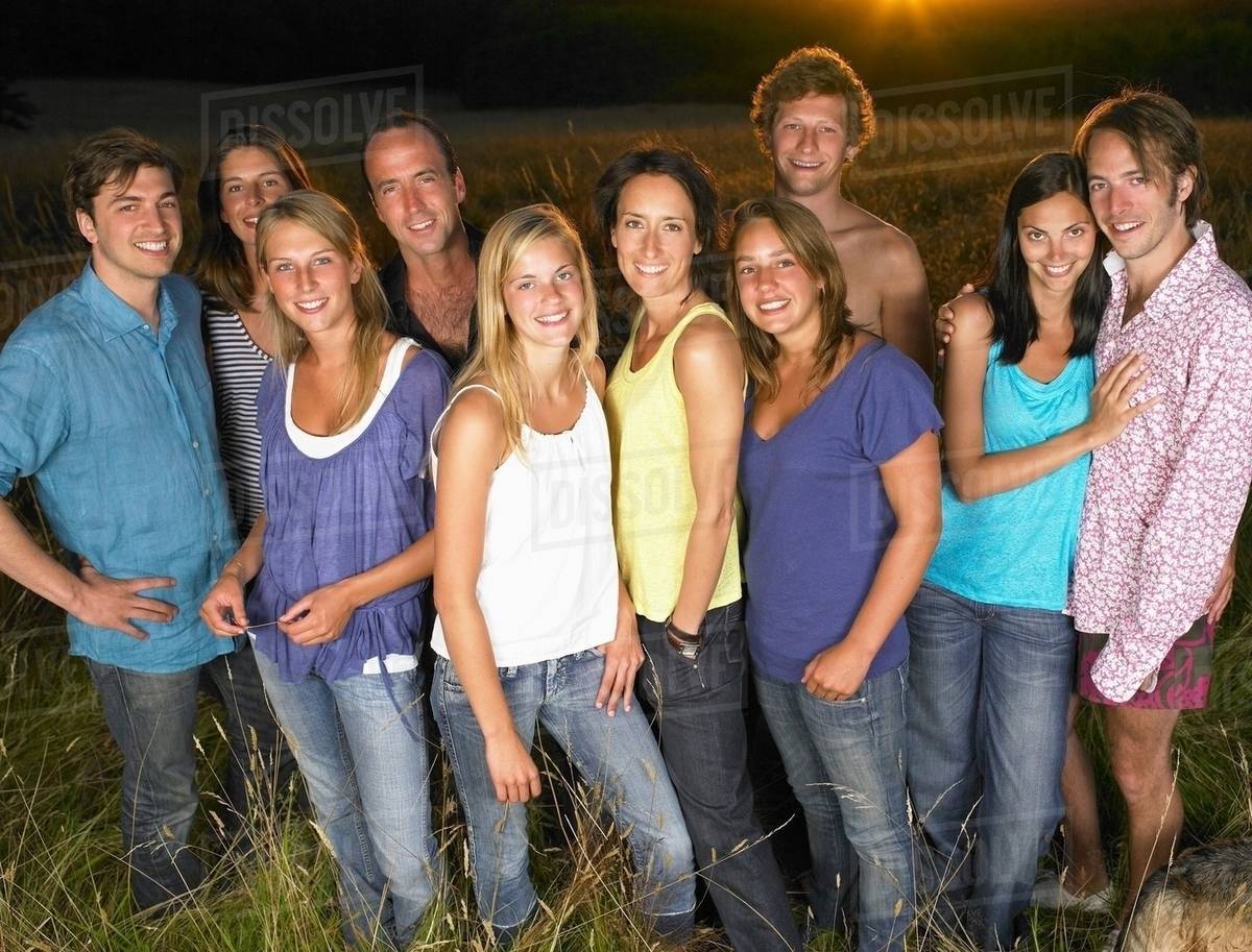 Group of friends in a field, smiling - Stock Photo - Dissolve