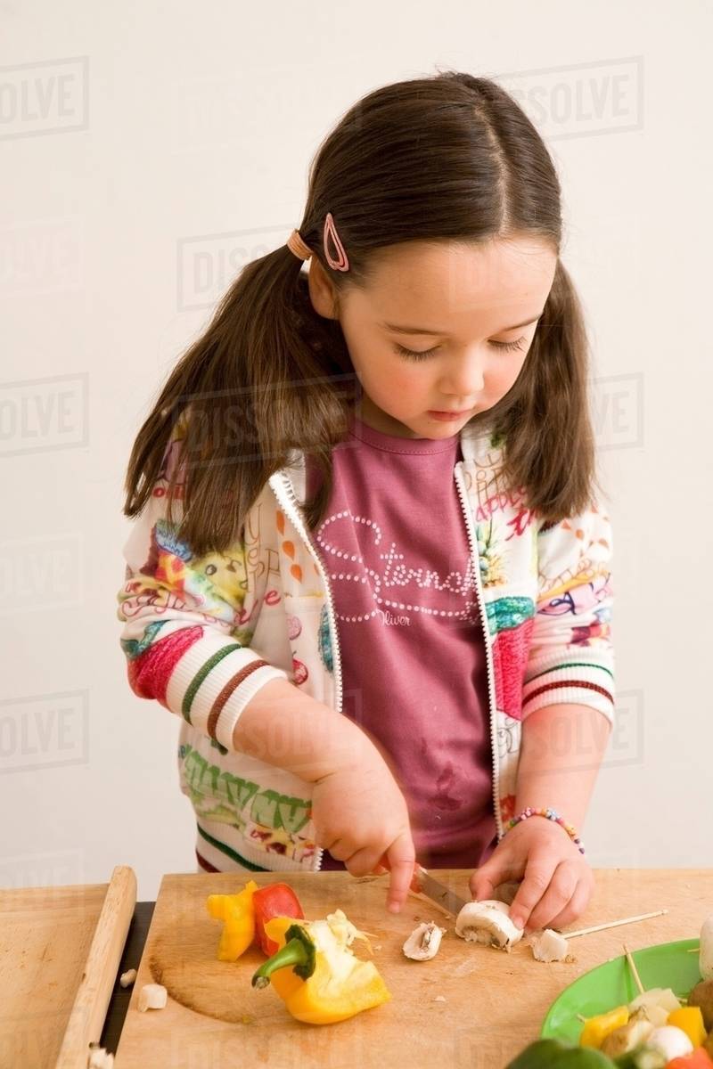 Girl cutting vegetables - Royalty-free Stock Photo | Dissolve