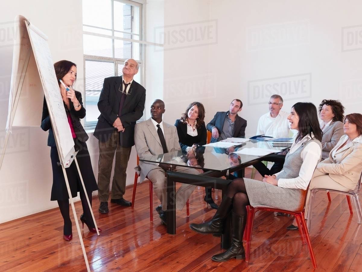 Co-workers giving presentation in office - Stock Photo - Dissolve