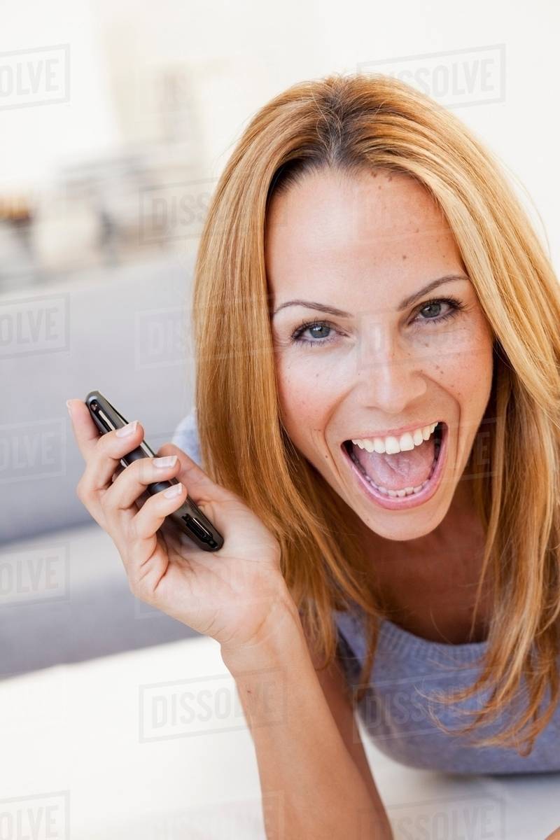 Young woman screaming into cell phone - Royalty-free Stock Photo | Dissolve