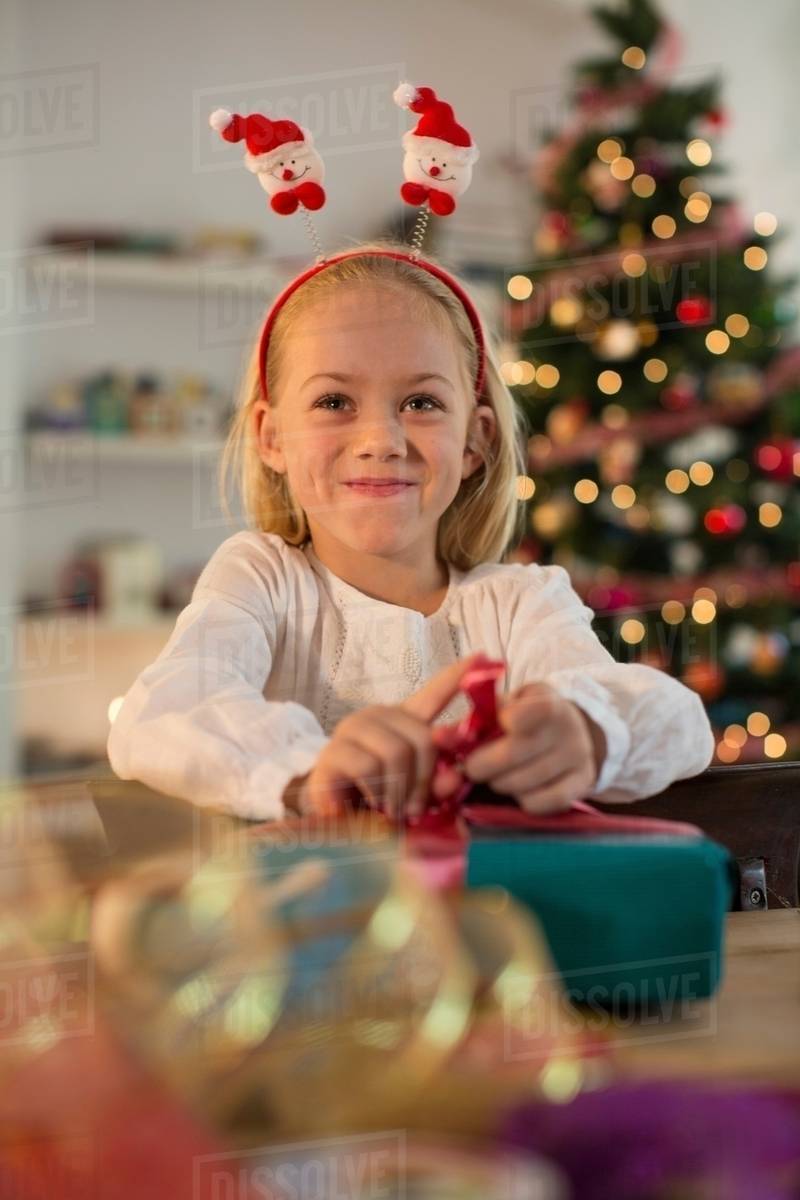 Girl wrapping Christmas presents - Stock Photo - Dissolve