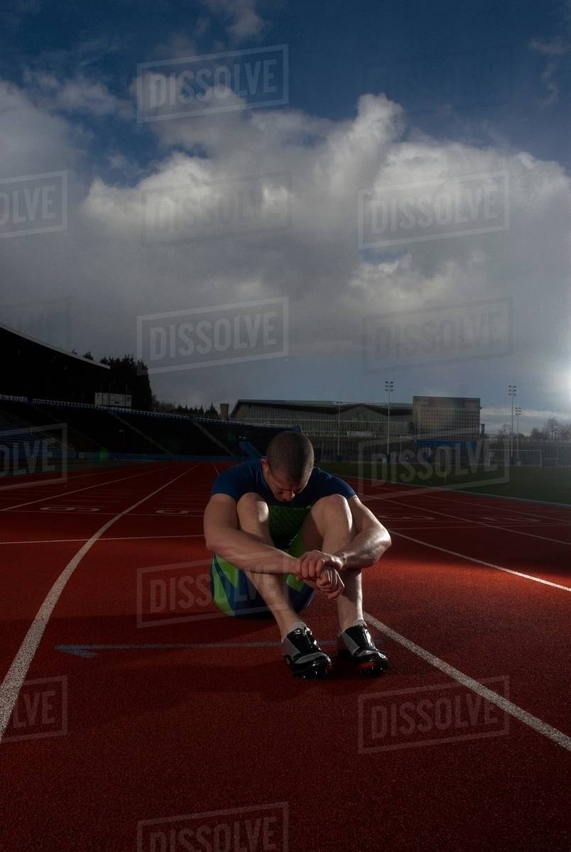 Athlete sitting on track - Royalty-free Stock Photo | Dissolve