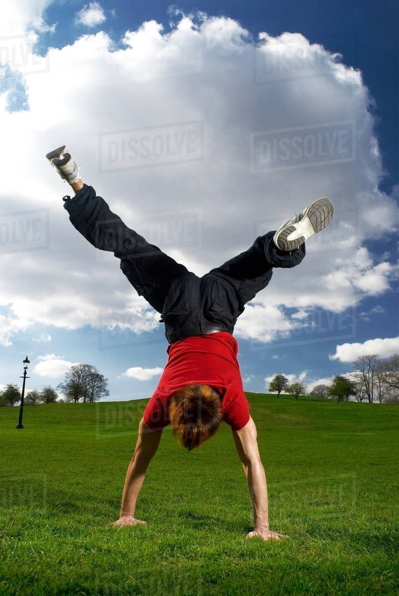Man performing handstand in park - Stock Photo - Dissolve