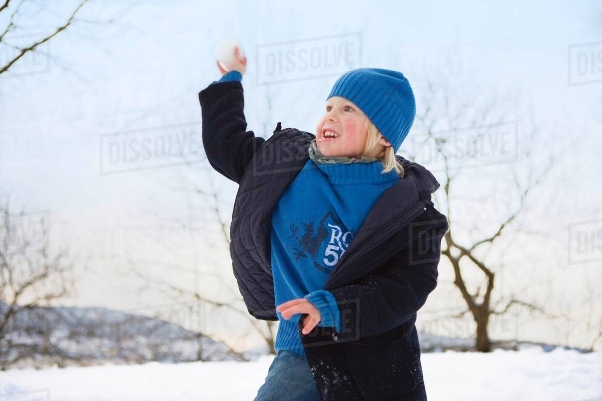 Scandinavian boy throwing snowball - Royalty-free Stock Photo | Dissolve