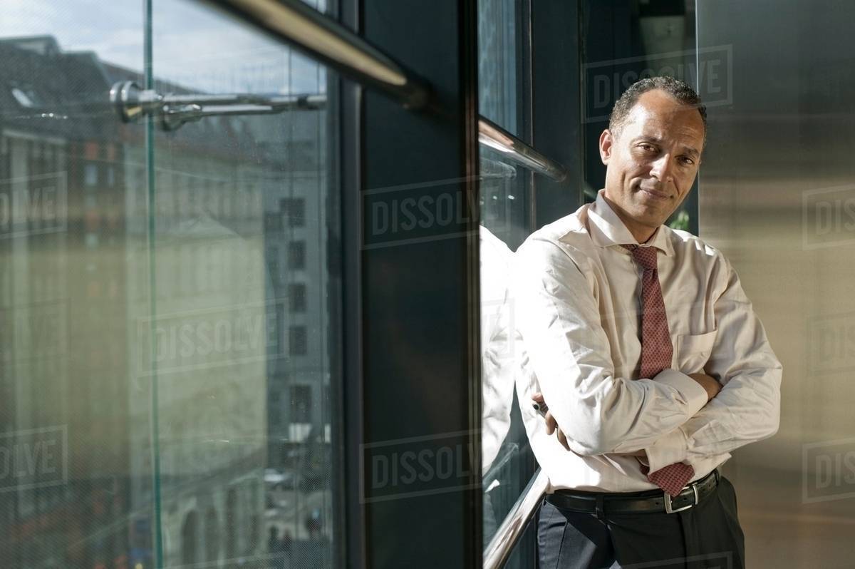 Man leaning at window smiling - Stock Photo - Dissolve