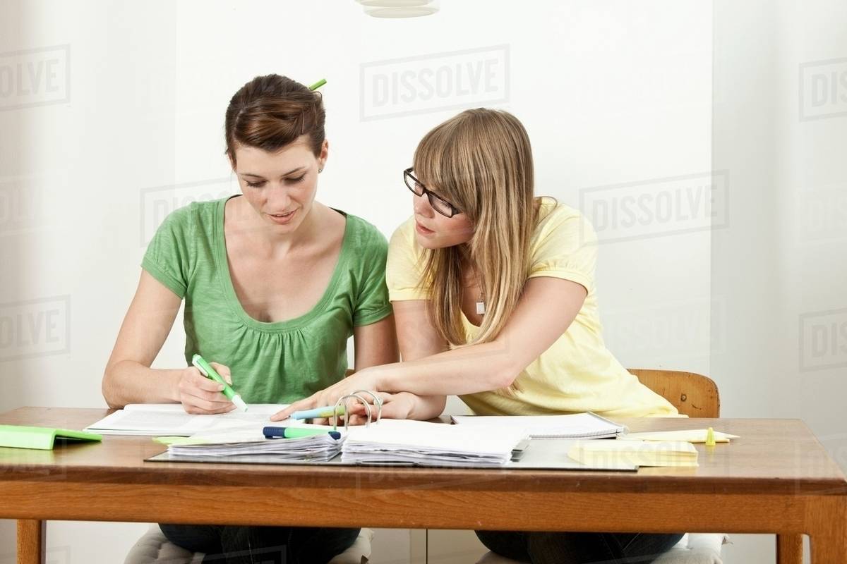 Two students sitting at table - Royalty-free Stock Photo | Dissolve