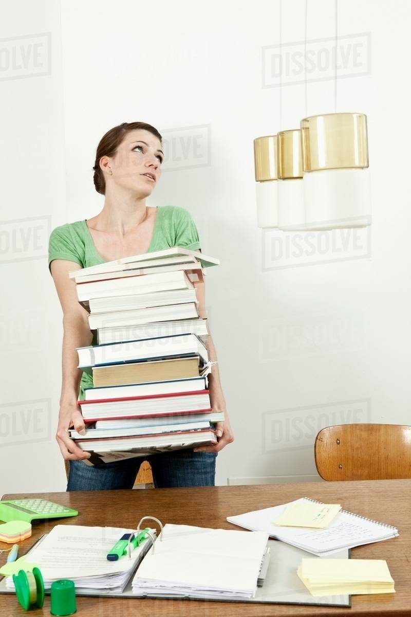 Female student carrying stack of books - Royalty-free Stock Photo ...