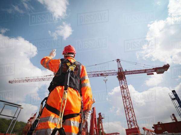 Crane Worker Directing Cranes - Stock Photo - Dissolve