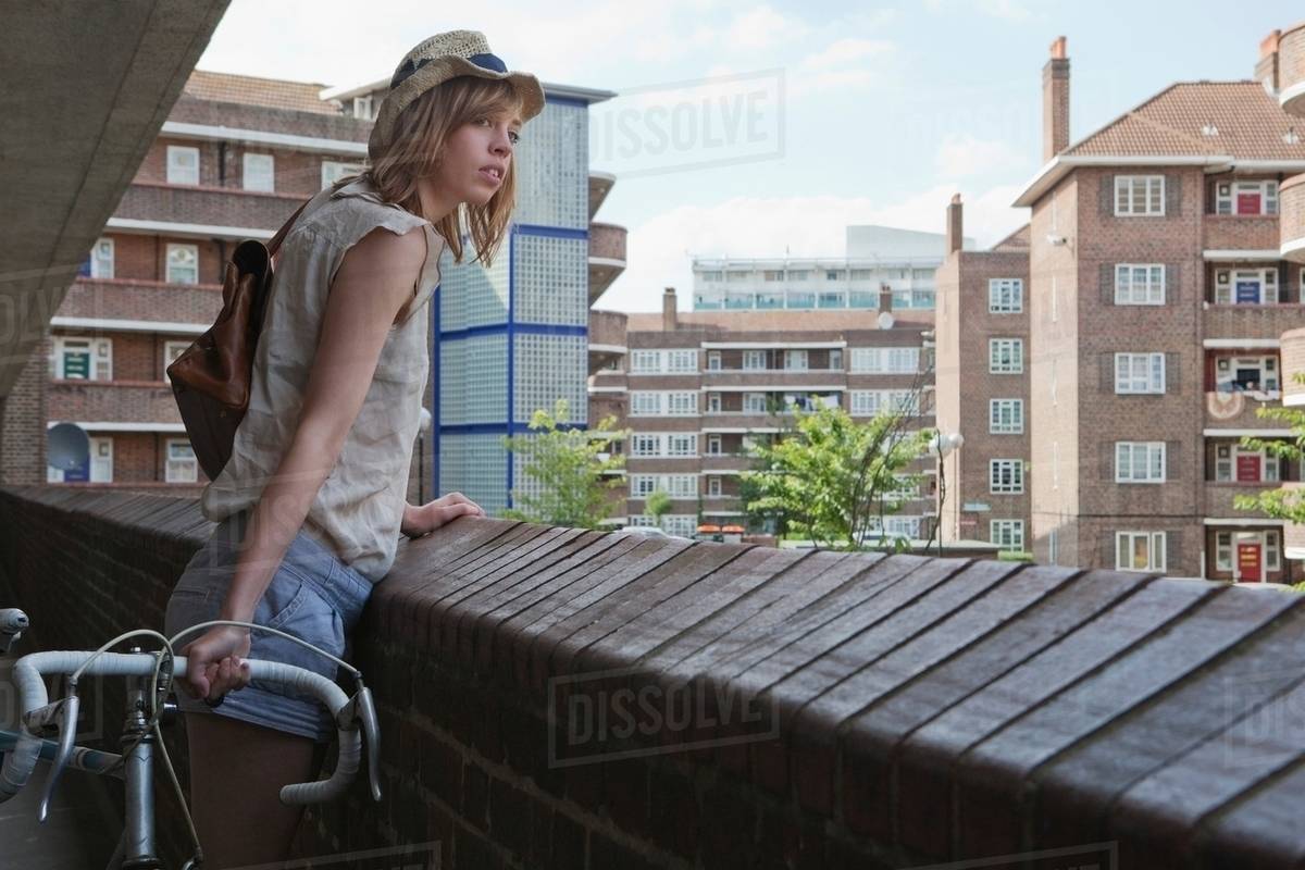 Woman looking over balcony - Royalty-free Stock Photo | Dissolve