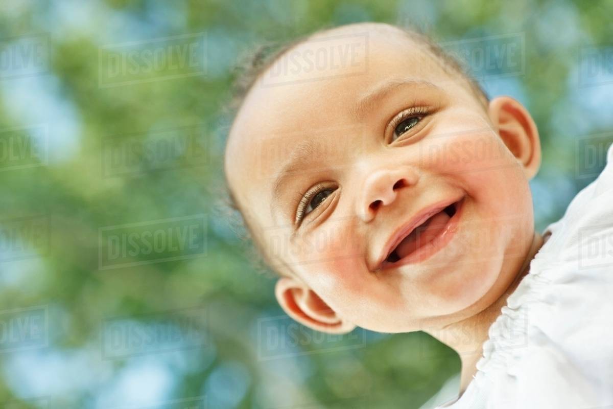 Baby smiling looking down at camera - Stock Photo - Dissolve