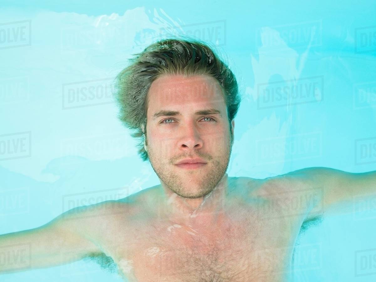 Young man floating in water - Stock Photo - Dissolve