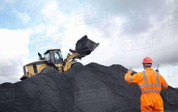 Coal Miner Instructing Digger - Stock Photo - Dissolve
