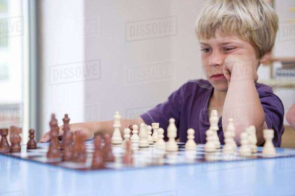 Boy playing chess - Royalty-free Stock Photo | Dissolve