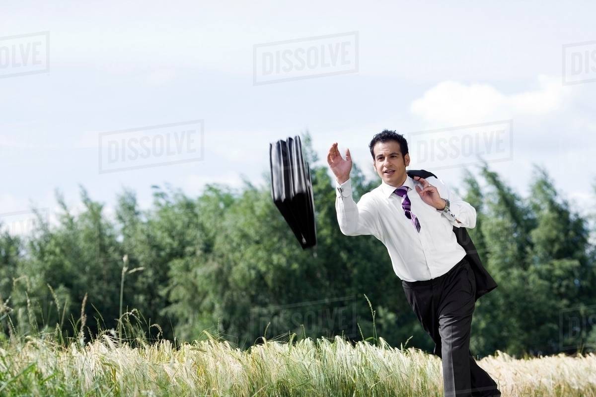 Man throwing briefcase - Stock Photo - Dissolve