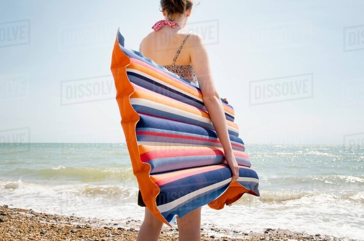 A girl with a Lilo at the beach - Royalty-free Stock Photo | Dissolve