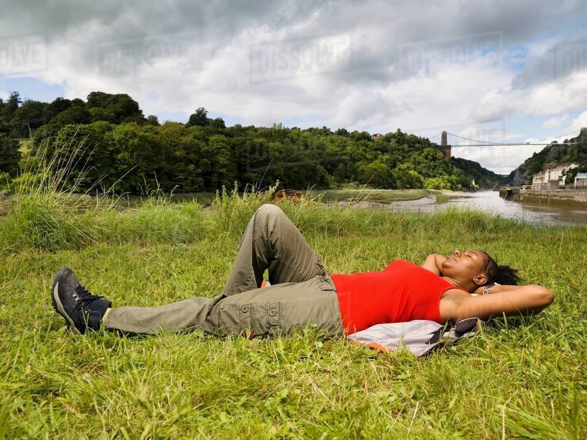 Woman relaxing by river - Royalty-free Stock Photo | Dissolve