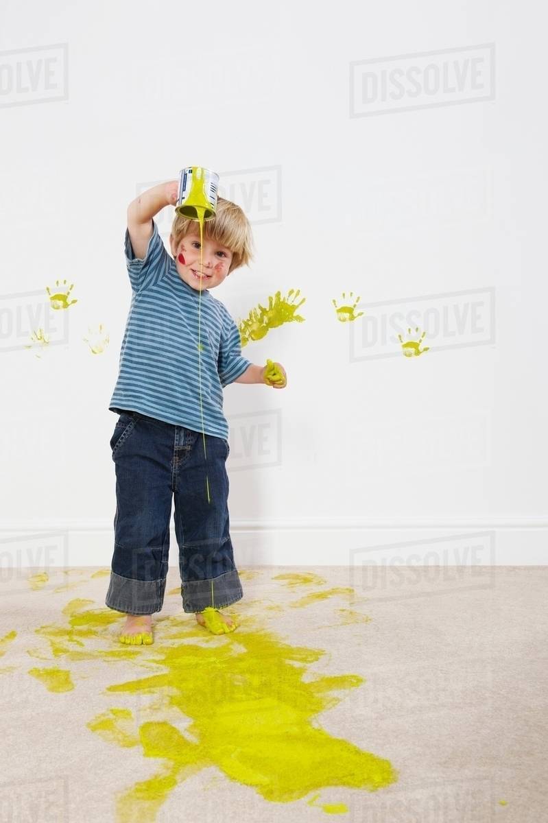 Toddler boy pouring paint onto carpet - Royalty-free Stock Photo | Dissolve