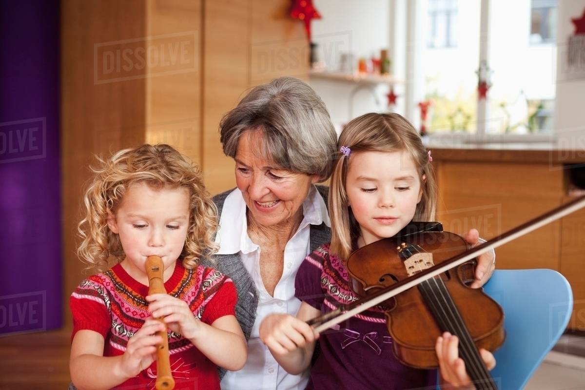 Grandma teaching grandchildren music - Stock Photo - Dissolve