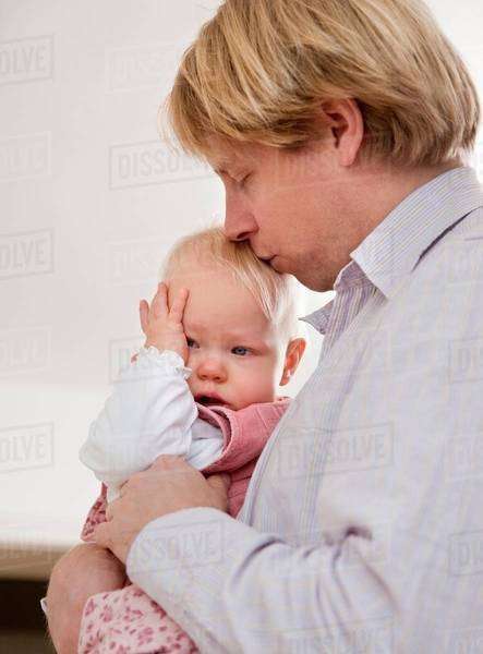 Father comforting crying baby - Royalty-free Stock Photo | Dissolve