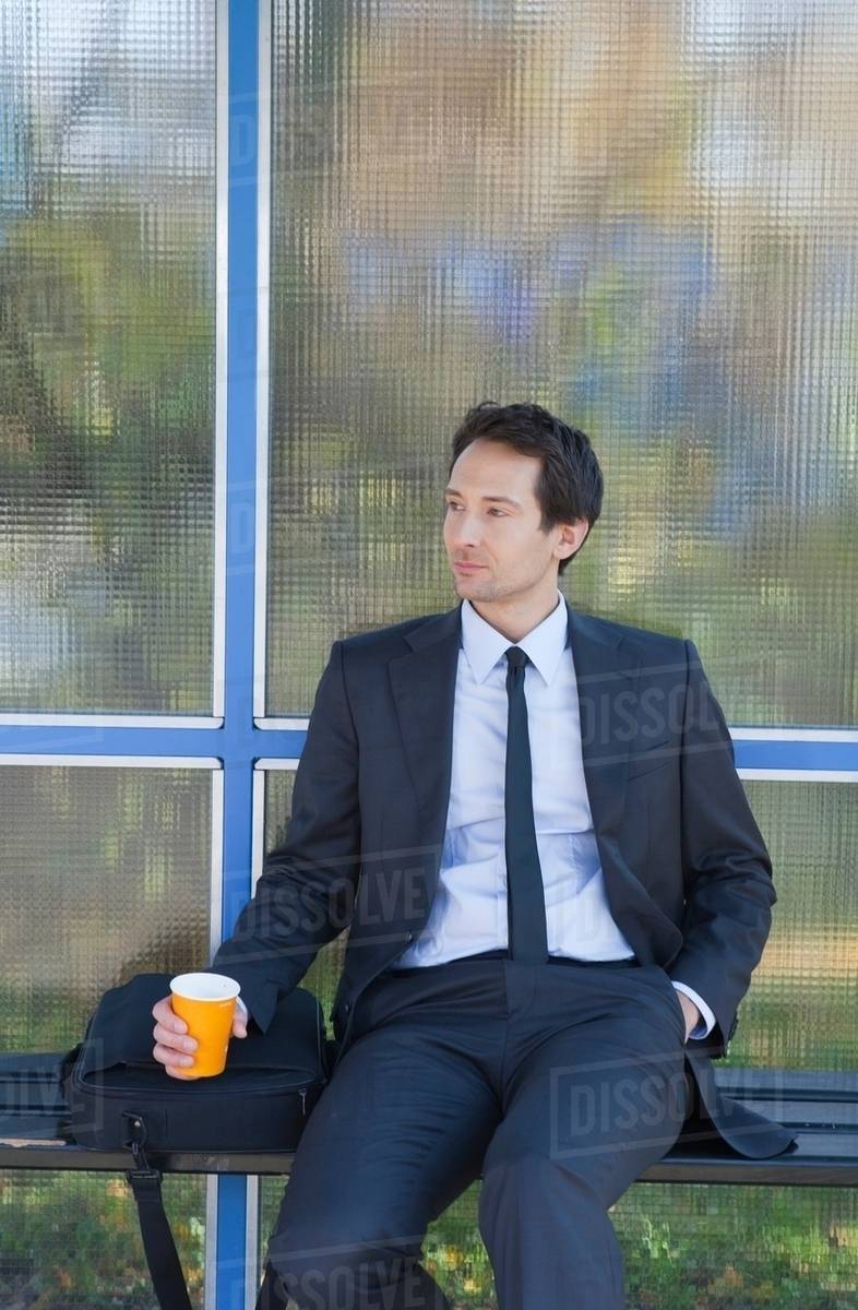 Businessman at bus stop, waiting - Royalty-free Stock Photo | Dissolve