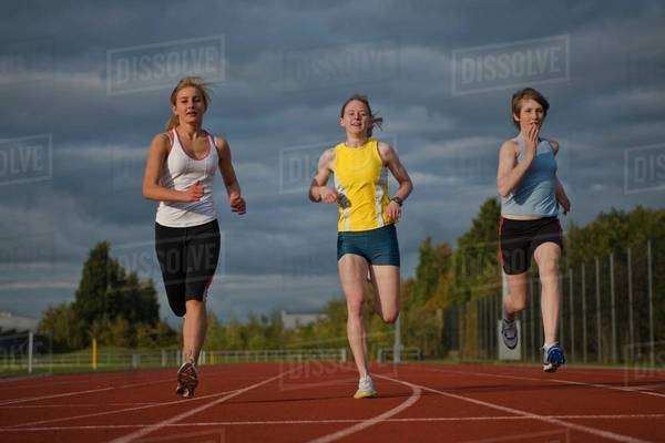 3 female athletes racing towards camera - Stock Photo - Dissolve