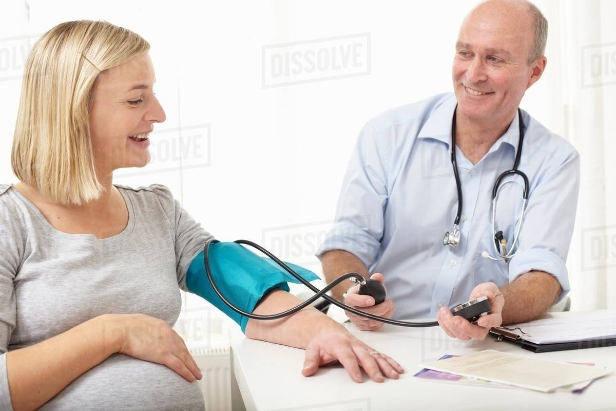 A doctor taking blood pressure - Royalty-free Stock Photo | Dissolve