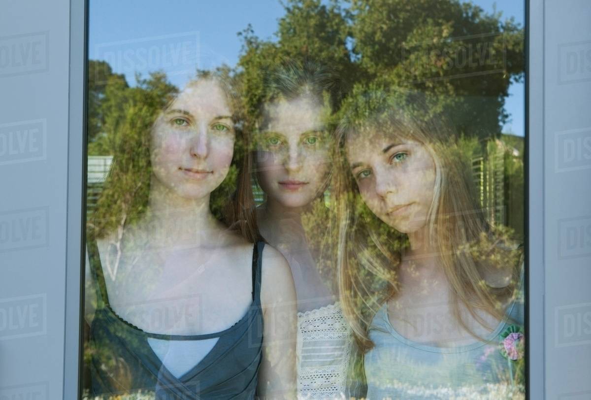 Girls looking through glass door - Royalty-free Stock Photo | Dissolve