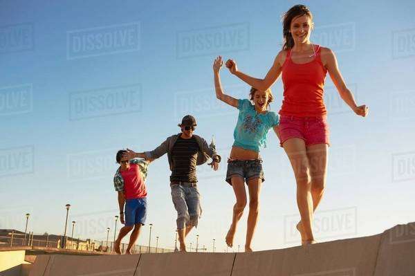 Young people balancing on wall - Royalty-free Stock Photo | Dissolve