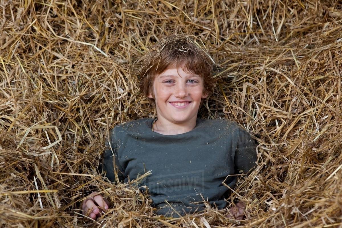 Boy in hay, smiling - Royalty-free Stock Photo | Dissolve