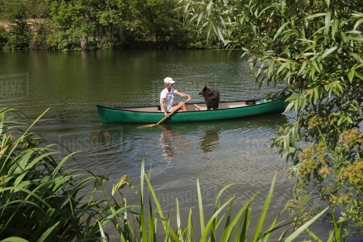 Woman in canoe with dog - Royalty-free Stock Photo | Dissolve
