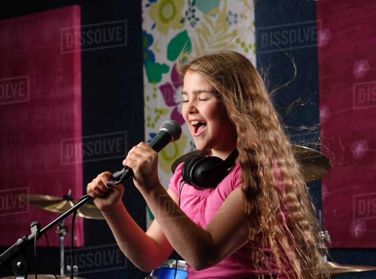 Young girl singing in studio - Royalty-free Stock Photo | Dissolve