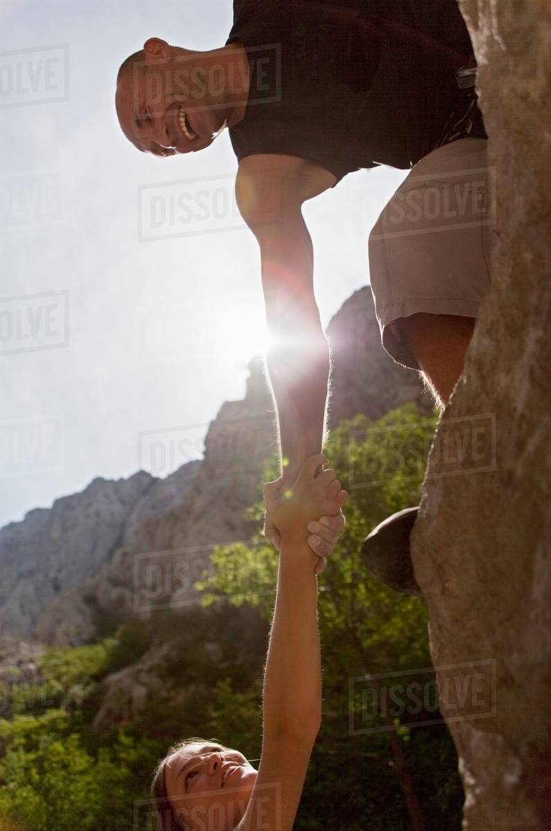 Rock climber helping partner - Royalty-free Stock Photo | Dissolve