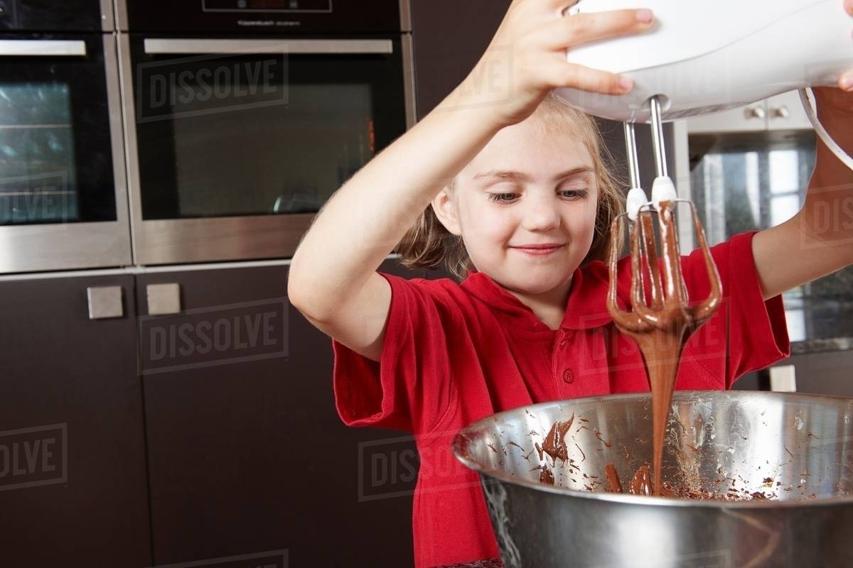 Girl making cake with mixing bowl - Stock Photo - Dissolve