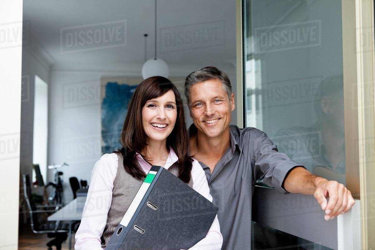 Business partners smiling to camera - Royalty-free Stock Photo | Dissolve