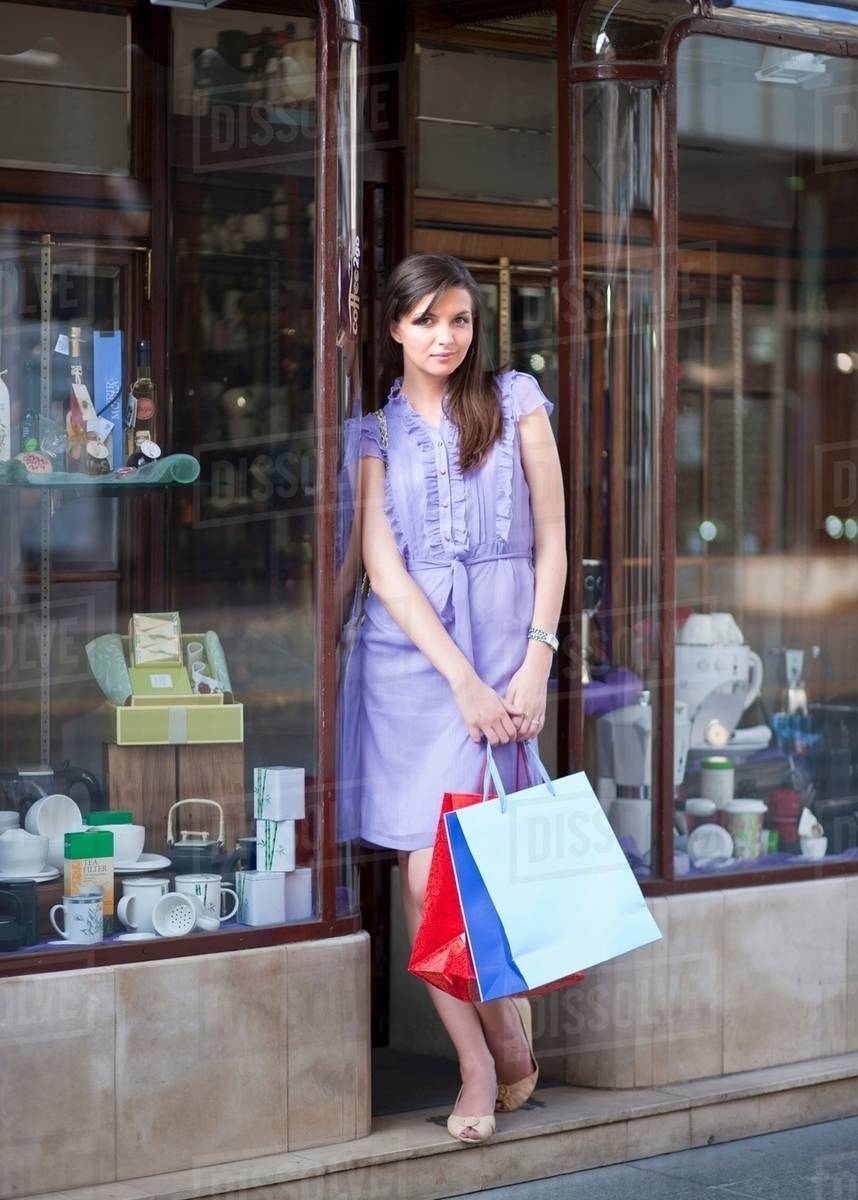 Young woman in front of store - Stock Photo - Dissolve