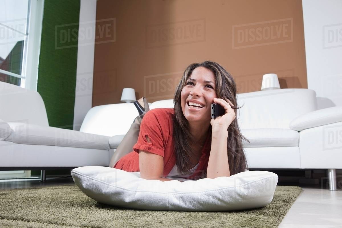 Young woman lying on ground using phone - Royalty-free Stock Photo ...