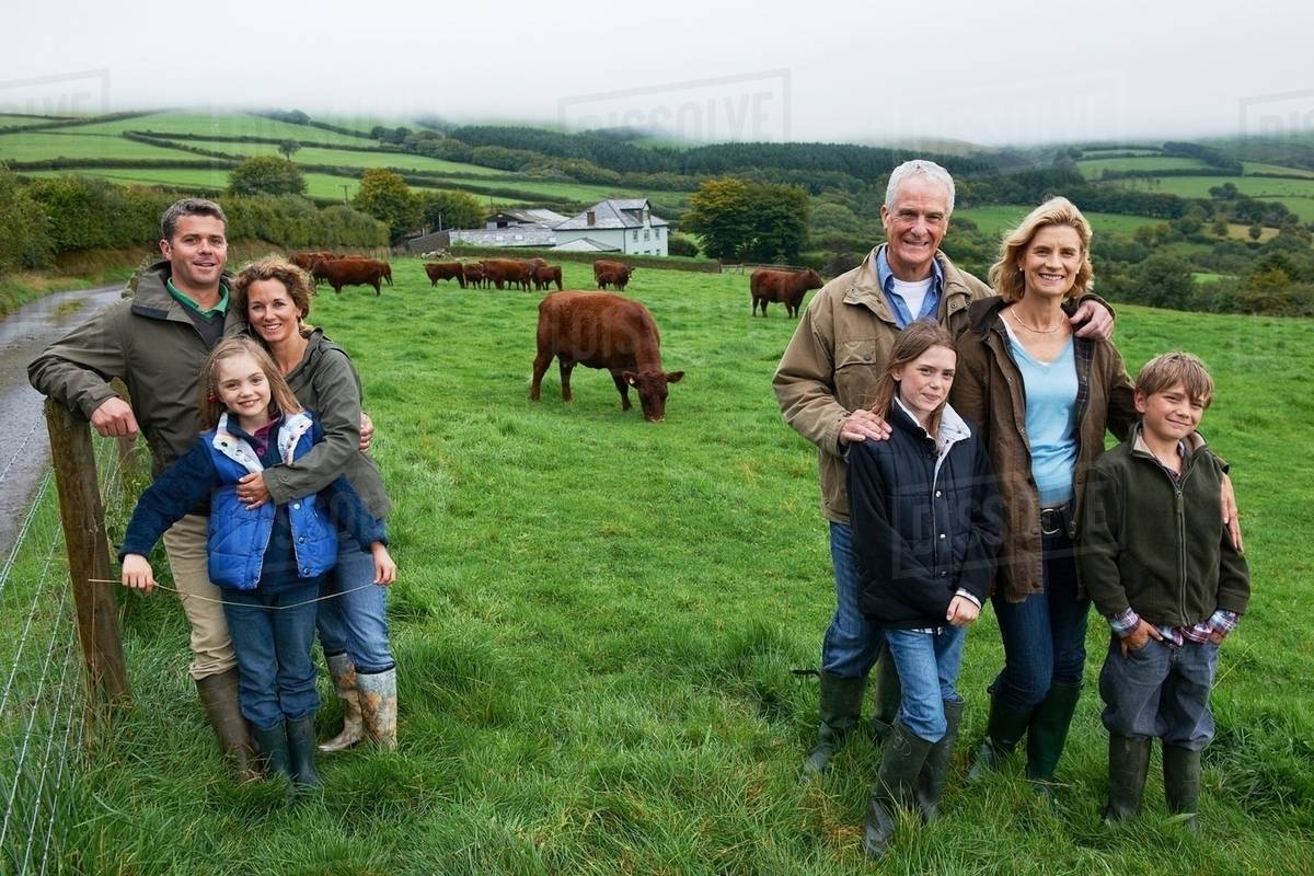 Family on farm in a field with cows - Royalty-free Stock Photo | Dissolve