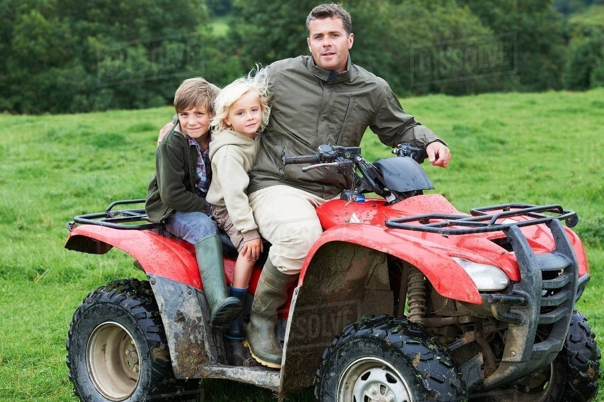 Father and kids on quad bike - Stock Photo - Dissolve